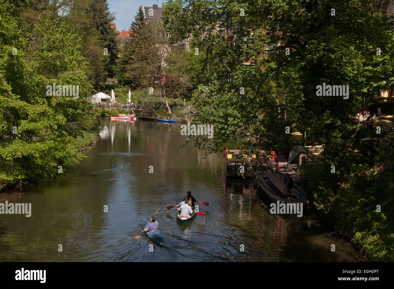 Oker old city ramparts, people paddling and rowing on the river Oker ...