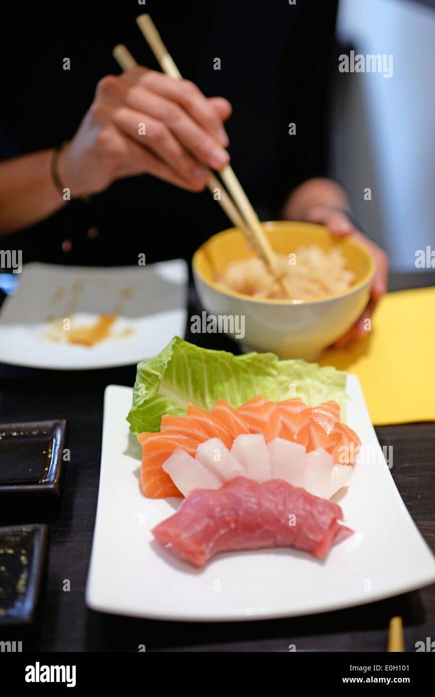 Woman eating white rice with sashimi Stock Photo - Alamy