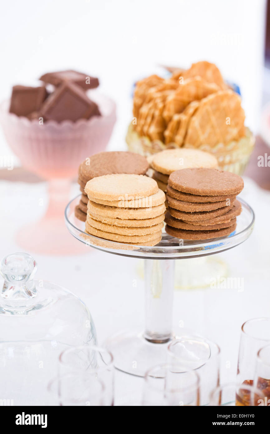 Closeup of four stacks of dry biscuits on glass serving stand with ...