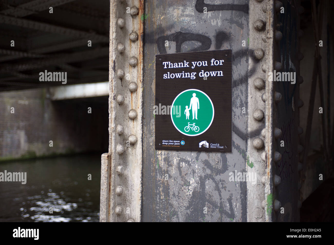 Sign asking cyclists to slow down on a London canal tow path Stock ...