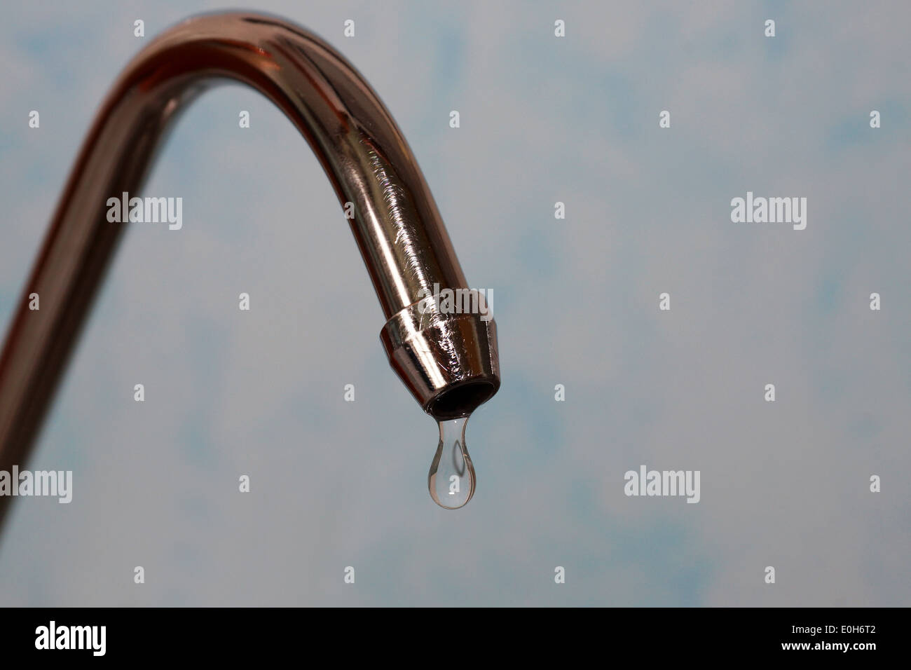 kitchen tap with water drops on a light-blue background Stock Photo - Alamy