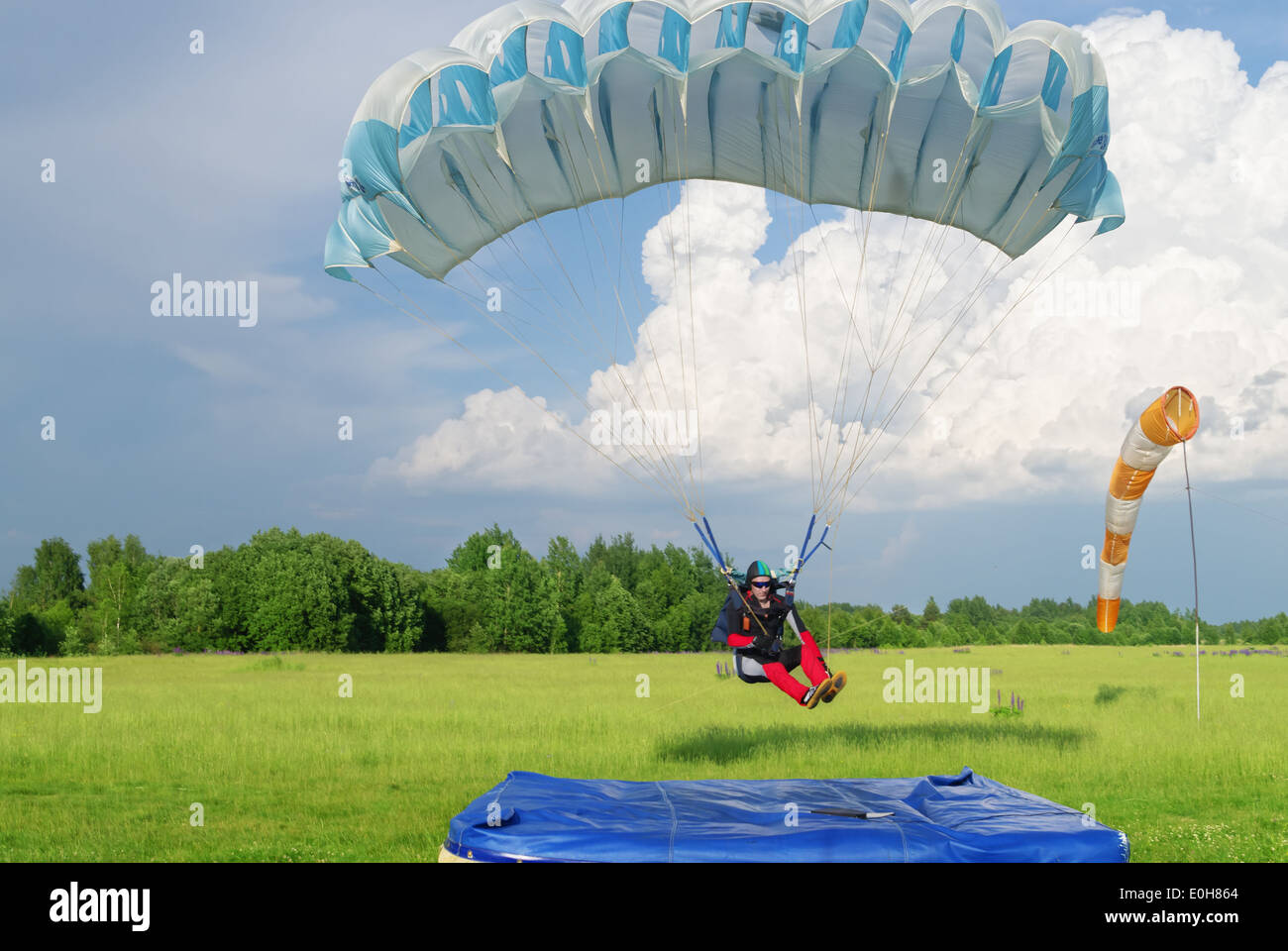 One day with parachutist in airfield. The skydiver landing under white ...
