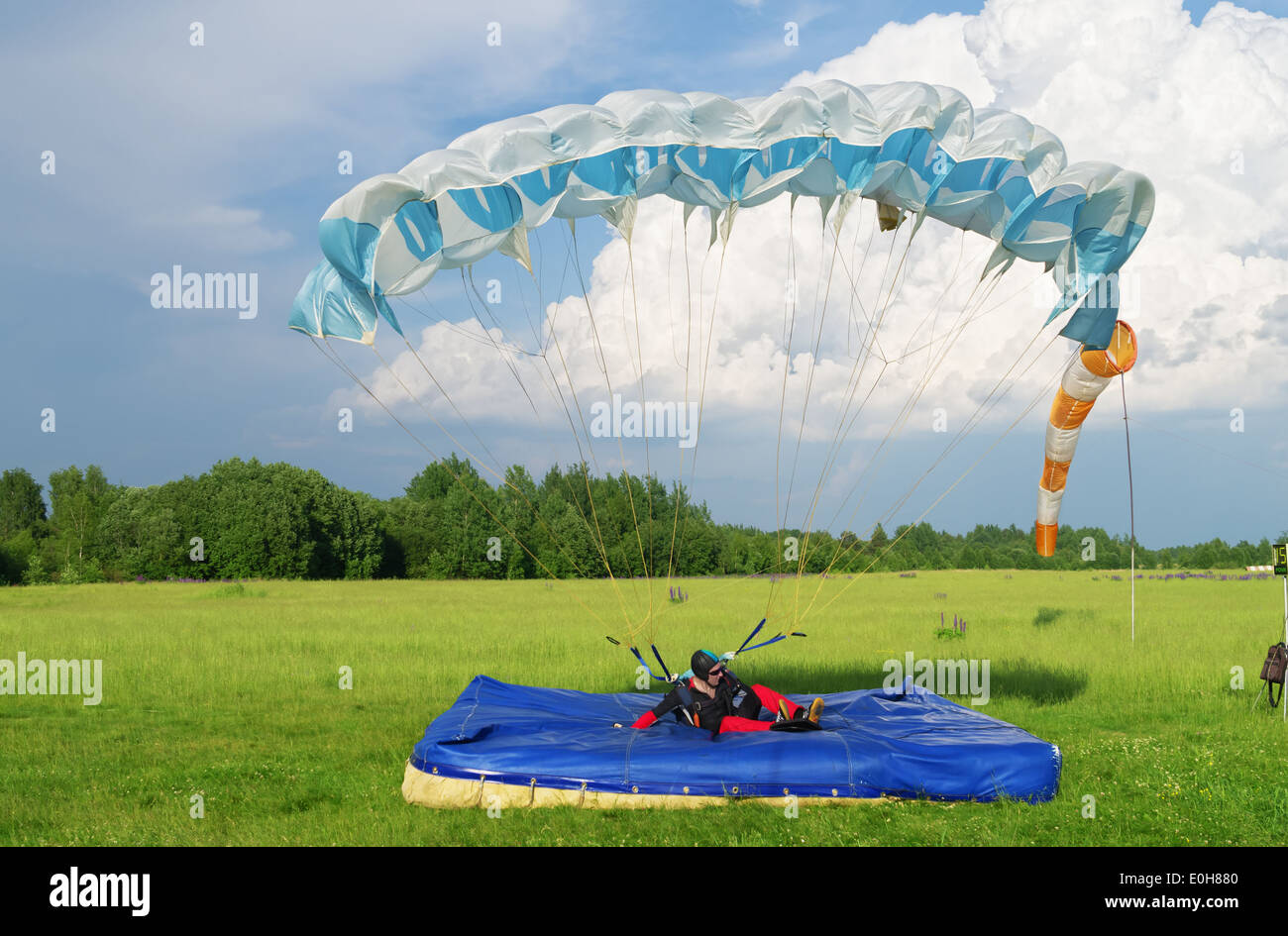 One day with parachutist in airfield. The skydiver landing under white ...
