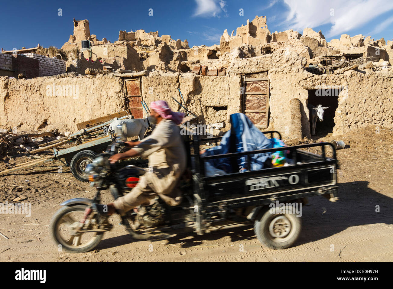 Man and veiled woman on a three-wheeler inside Shali fort. Siwa Oasis ...