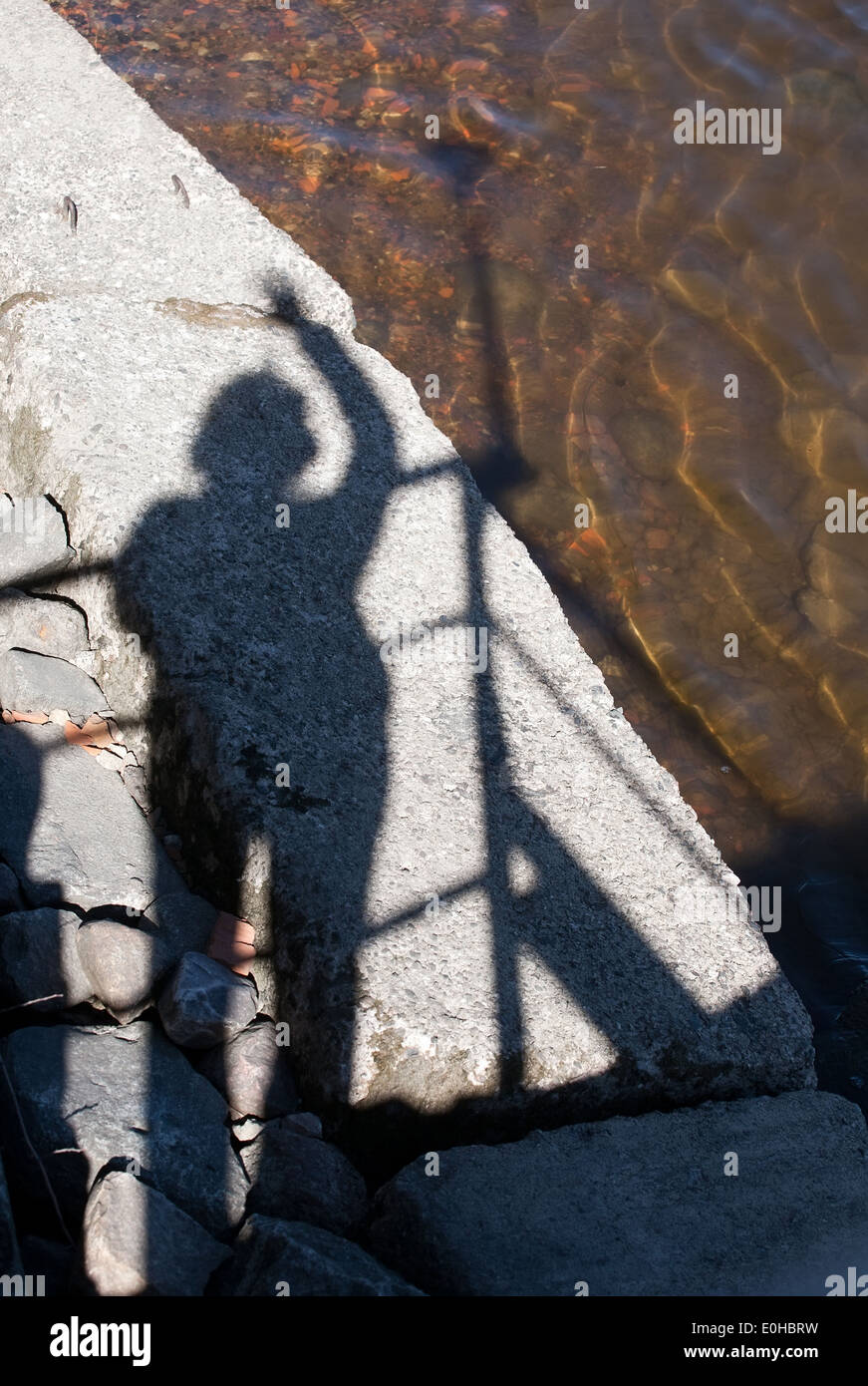 closeup black shadow of woman standing on embankment and waving hand ...