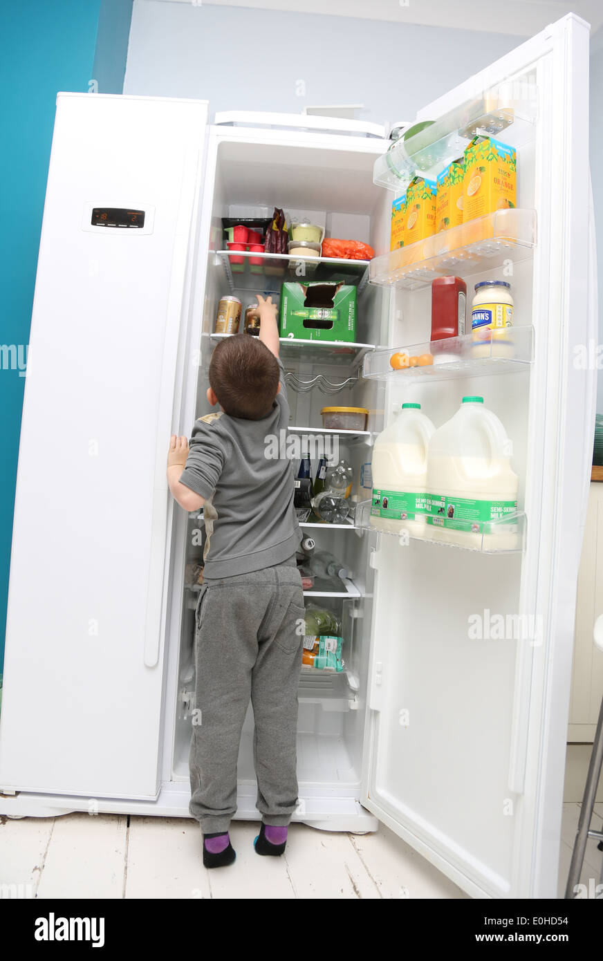 5 year old boy helping himself from the fridge Stock Photo - Alamy