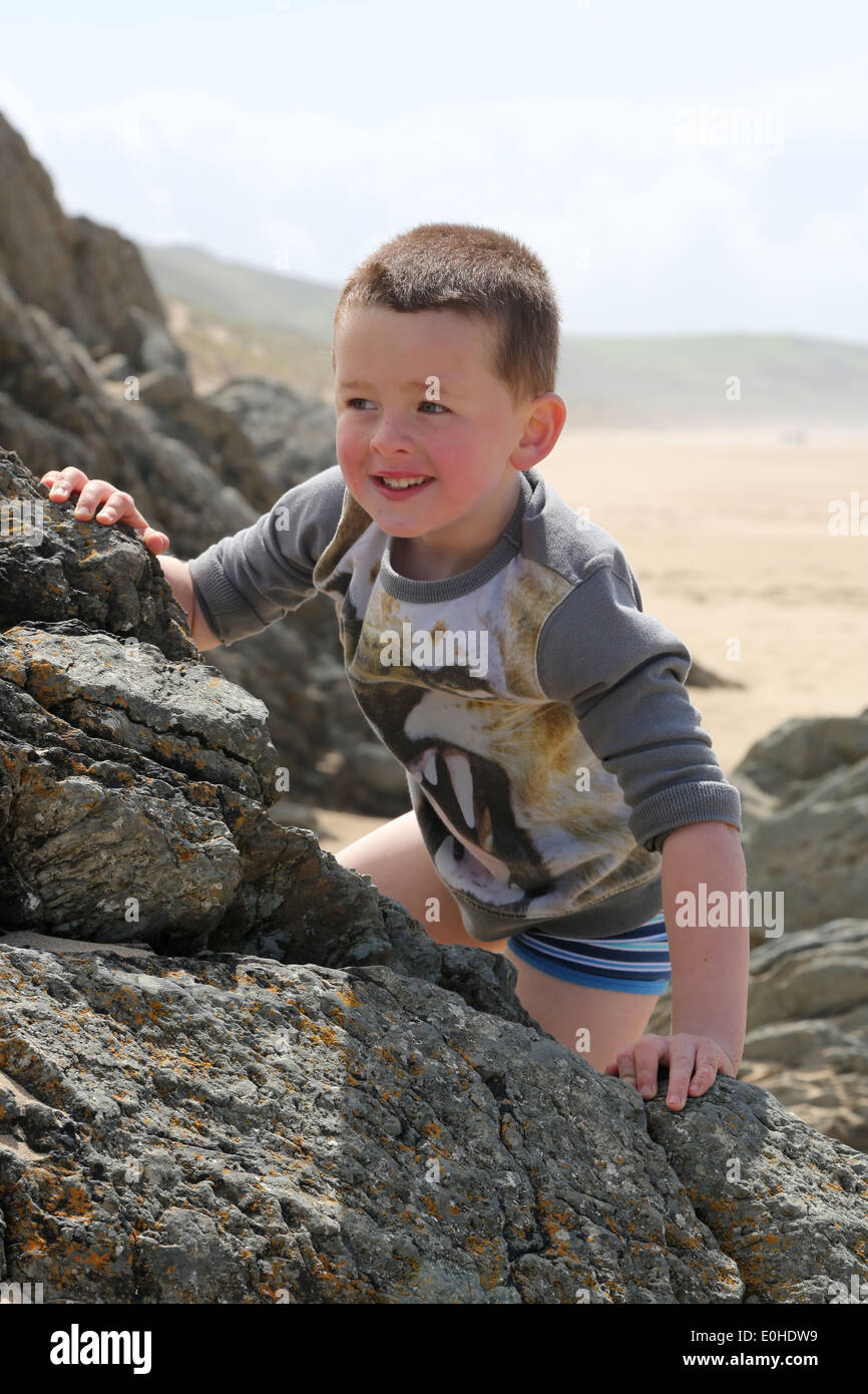 Boy climbing rocks Stock Photo - Alamy