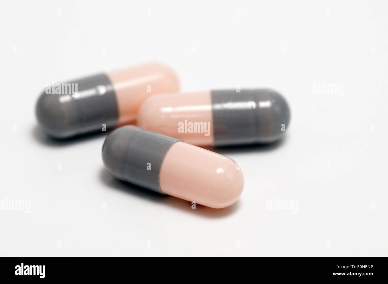 Three capsules or pills on white background Stock Photo - Alamy
