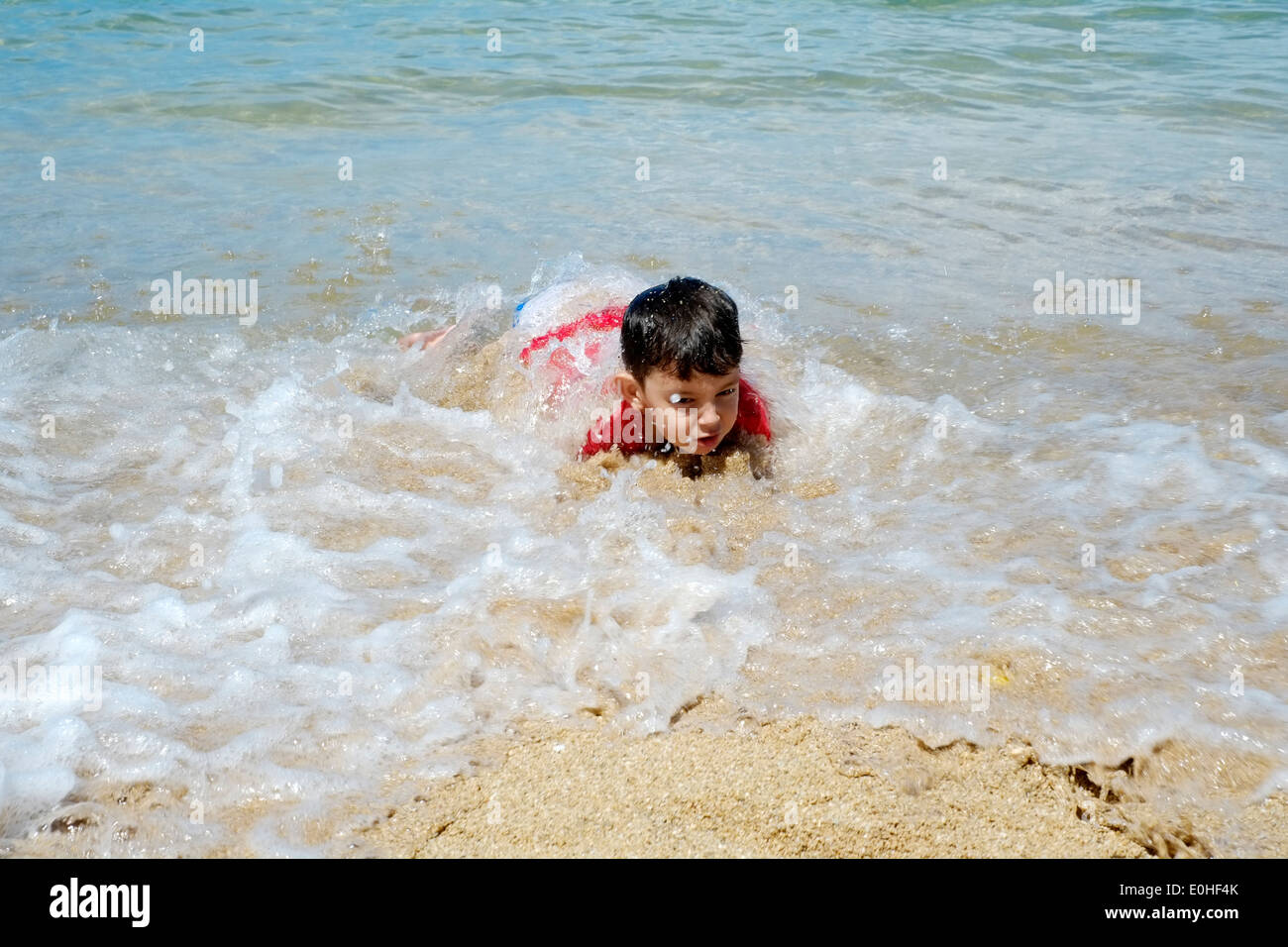 young boy paddles off the beach and in sea at balekambang east java ...