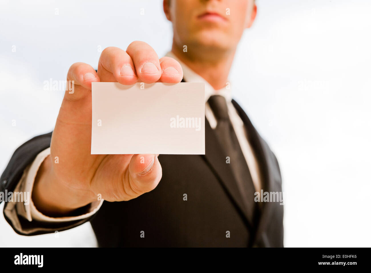 Man's hand showing business card. Black suit and tie Stock Photo - Alamy