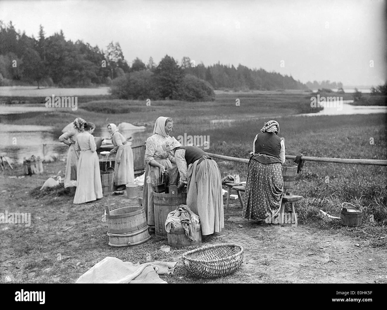 A historical photo from Sweden showing women washing clothes by a lake ...