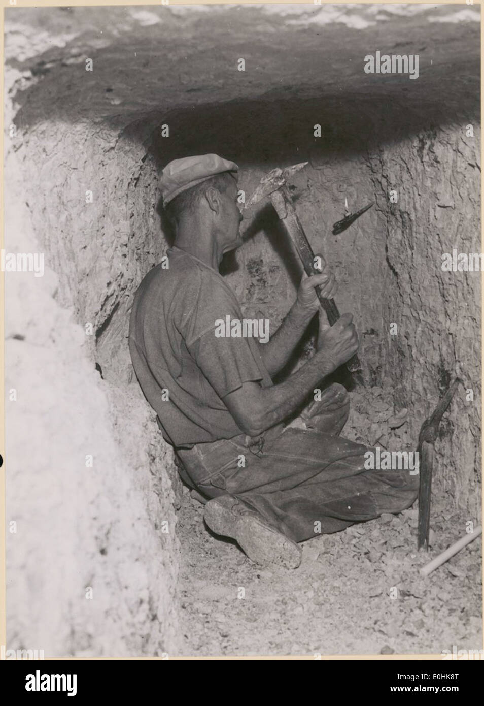 Opal miner, George Lowe chips away at the face of his opal mine ...