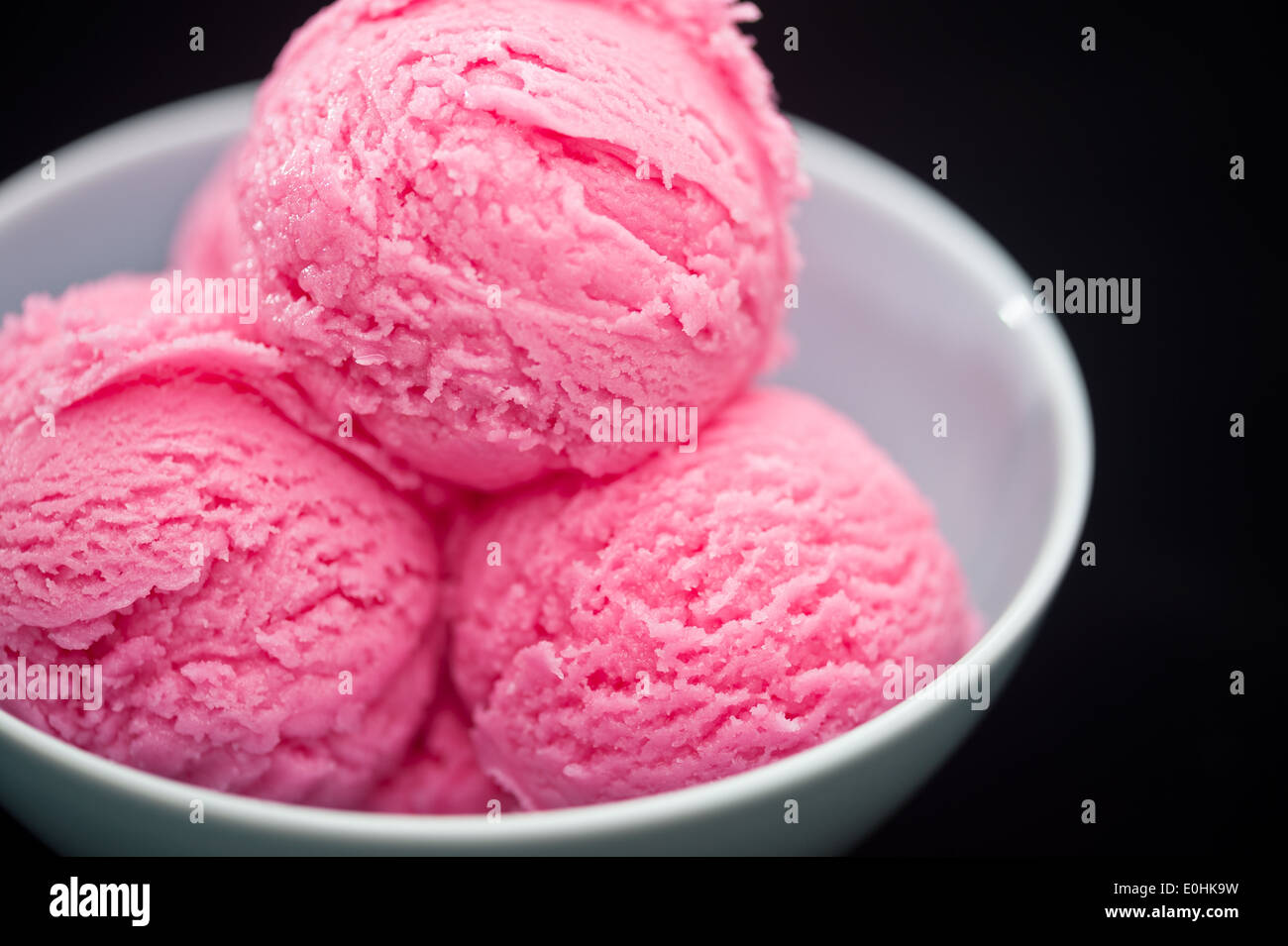 Raspberry ice cream cup over black background Stock Photo - Alamy