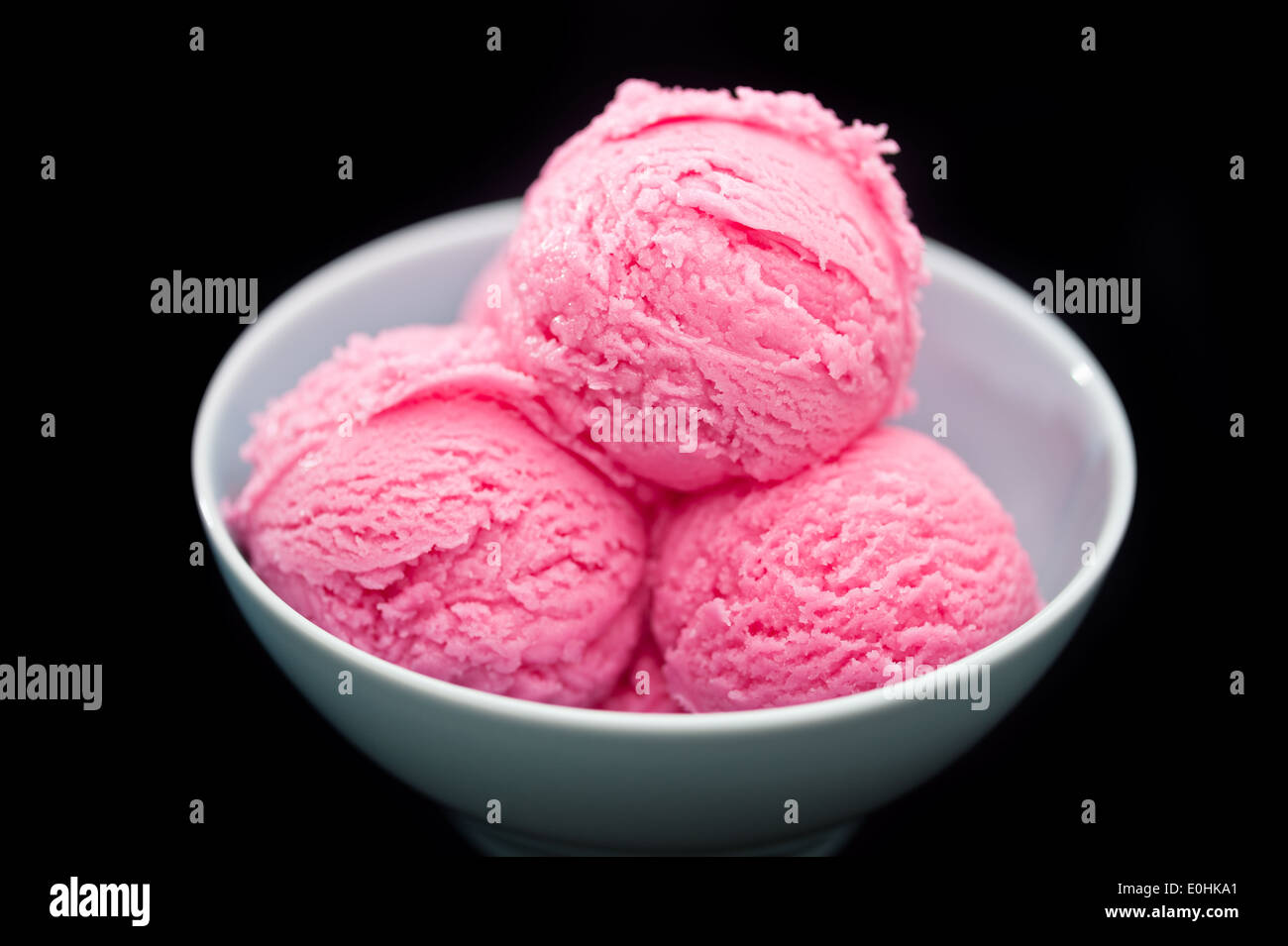Raspberry ice cream cup over black background Stock Photo - Alamy