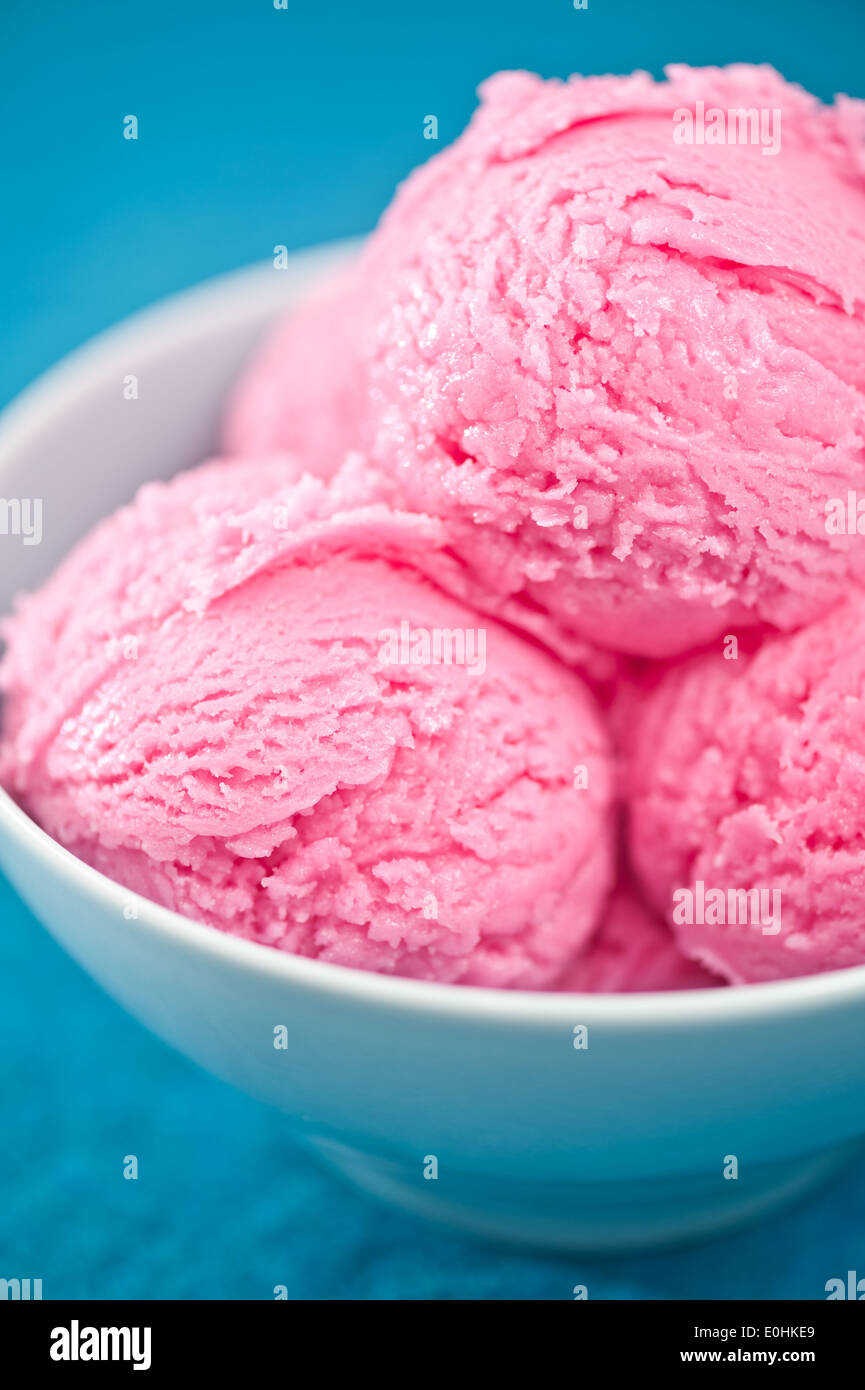 Raspberry ice cream cup over bBLUE background Stock Photo - Alamy