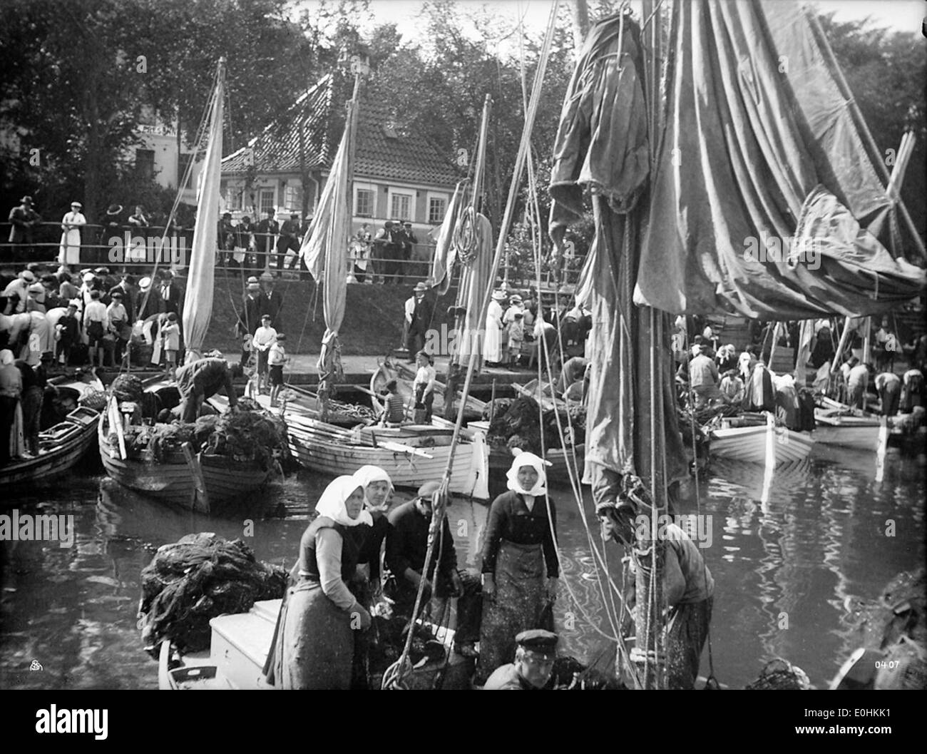 This photograph shows people and boats in either Halland or Skåne ...