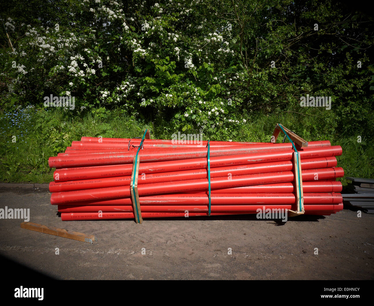 Red pipes waiting to get used Stock Photo - Alamy