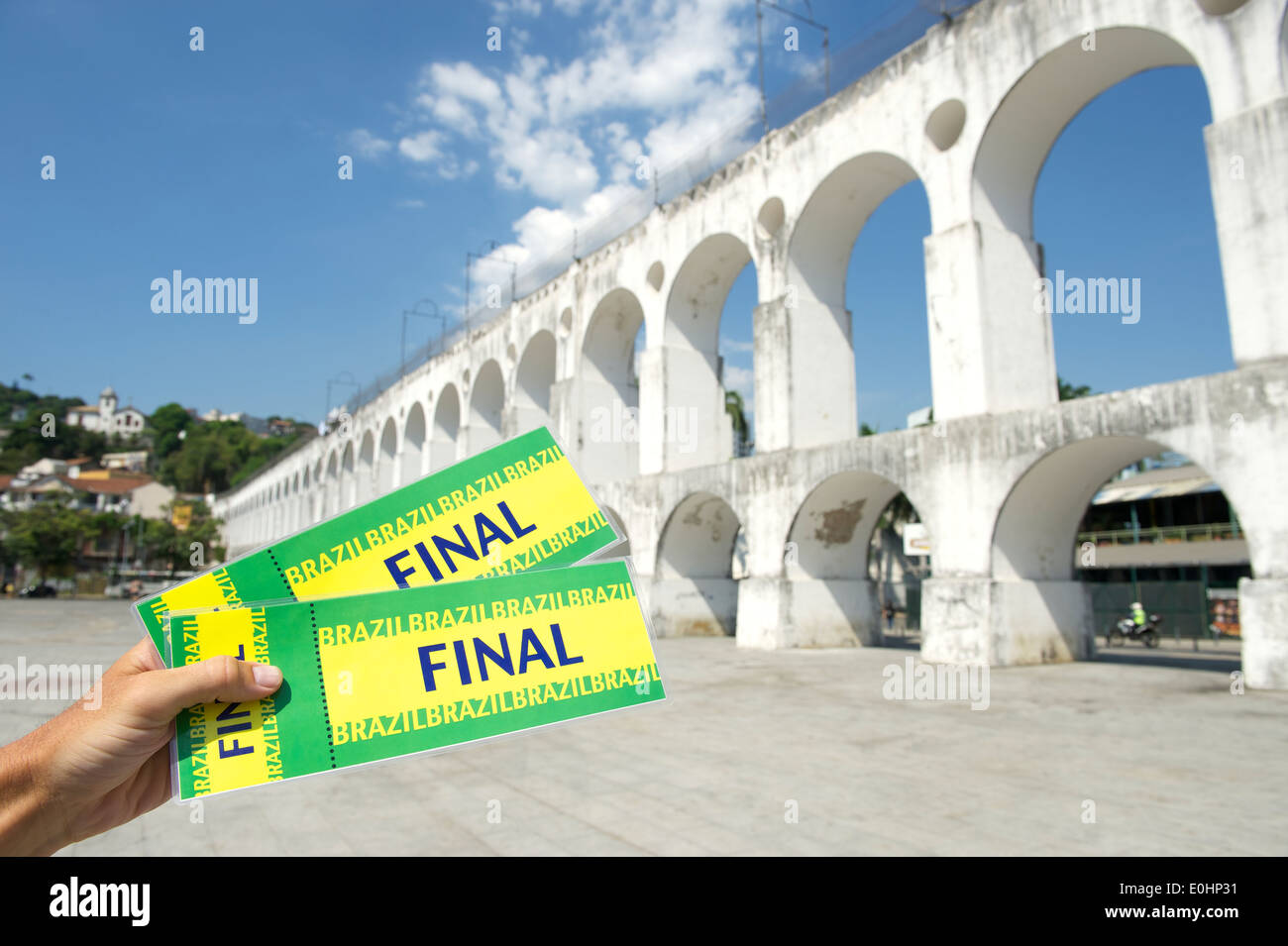 Hand holding two Brazil final tickets in front of Arcos da Lapa Arches ...