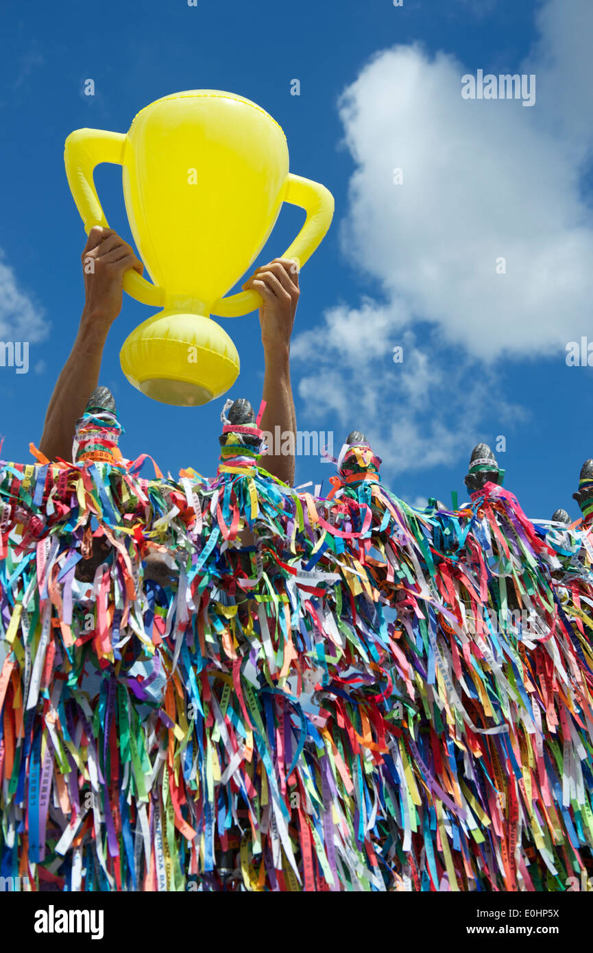 Hands holding good luck championship trophy at wall of Brazilian wish ...