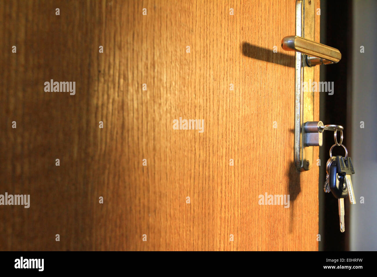 Keys left in the lock of a slightly open door Stock Photo - Alamy