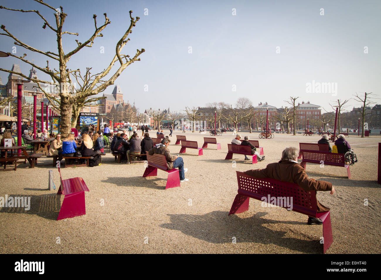 People sitting on benches in the sun in Museumplein museumsquare ...