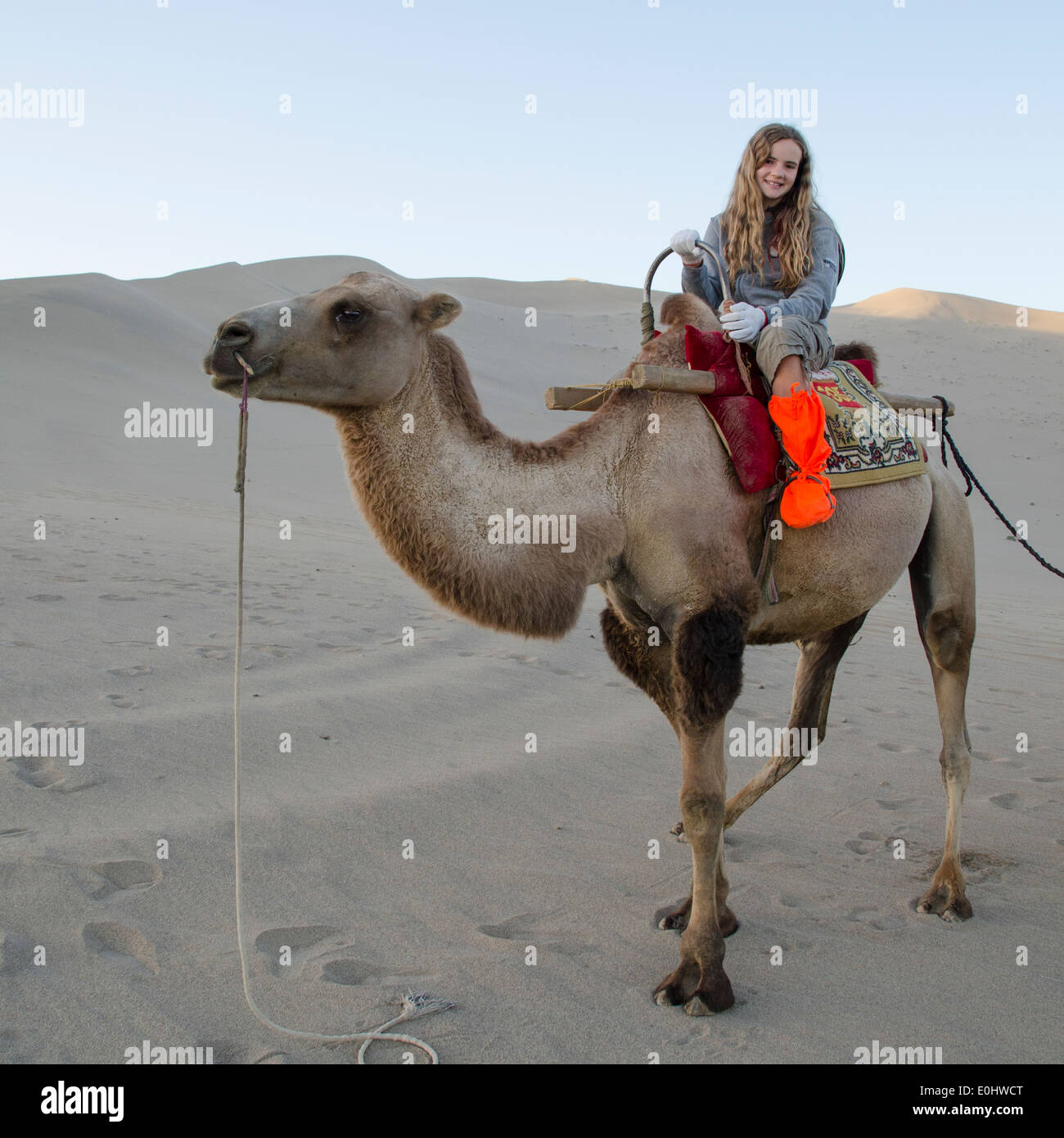 Girl riding camel at Mingsha Shan, Dunhuang, Jiuquan, Gansu Province ...