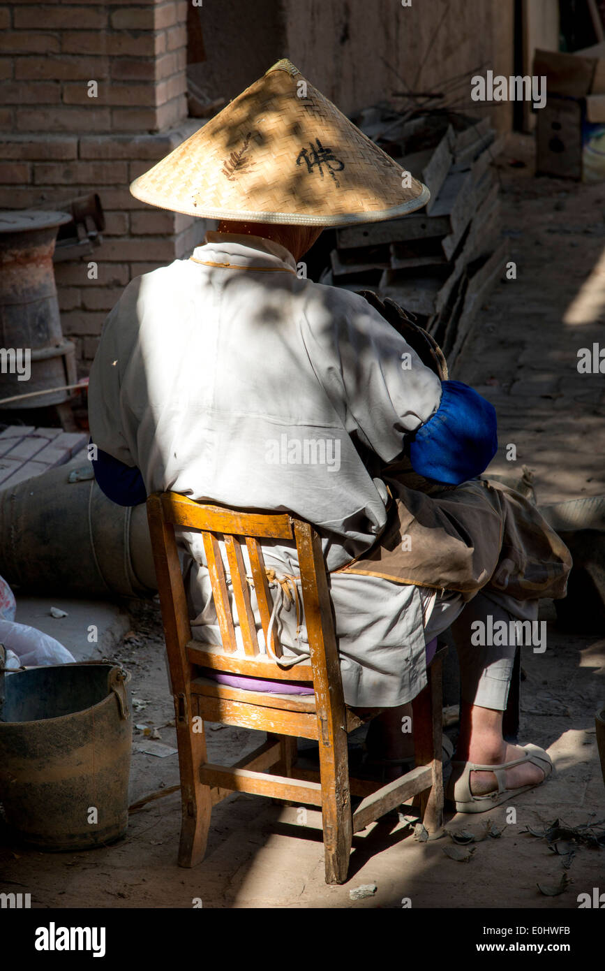 Man sitting on chair at Lei Yinsi Temple, Dunhuang, Jiuquan, Gansu ...
