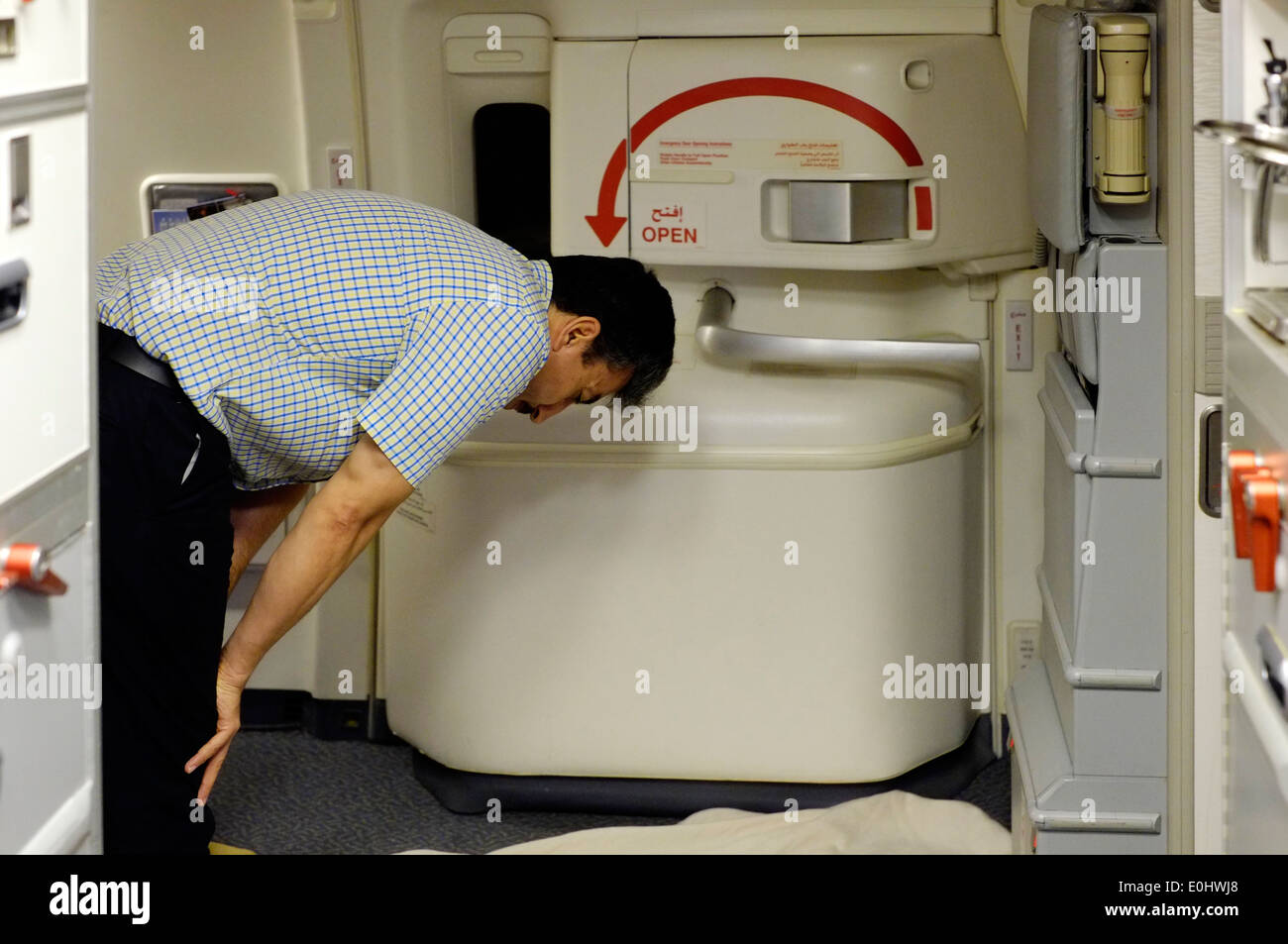 male muslim passenger on board an emirates flight prays towards mecca ...