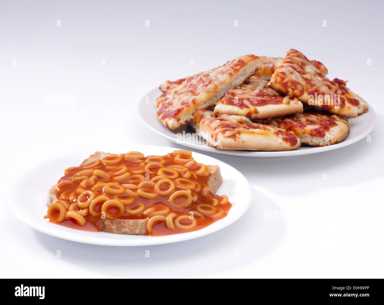 a serving of spaghetti hoops on toast and a plate of pizza slices on a ...