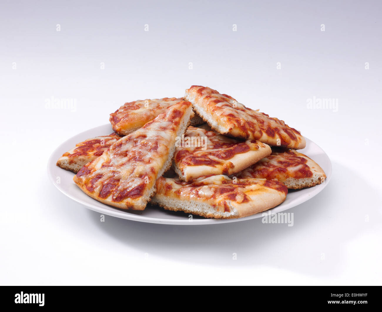 A white plate with slices of cheese and tomato pizza pile on it Stock ...