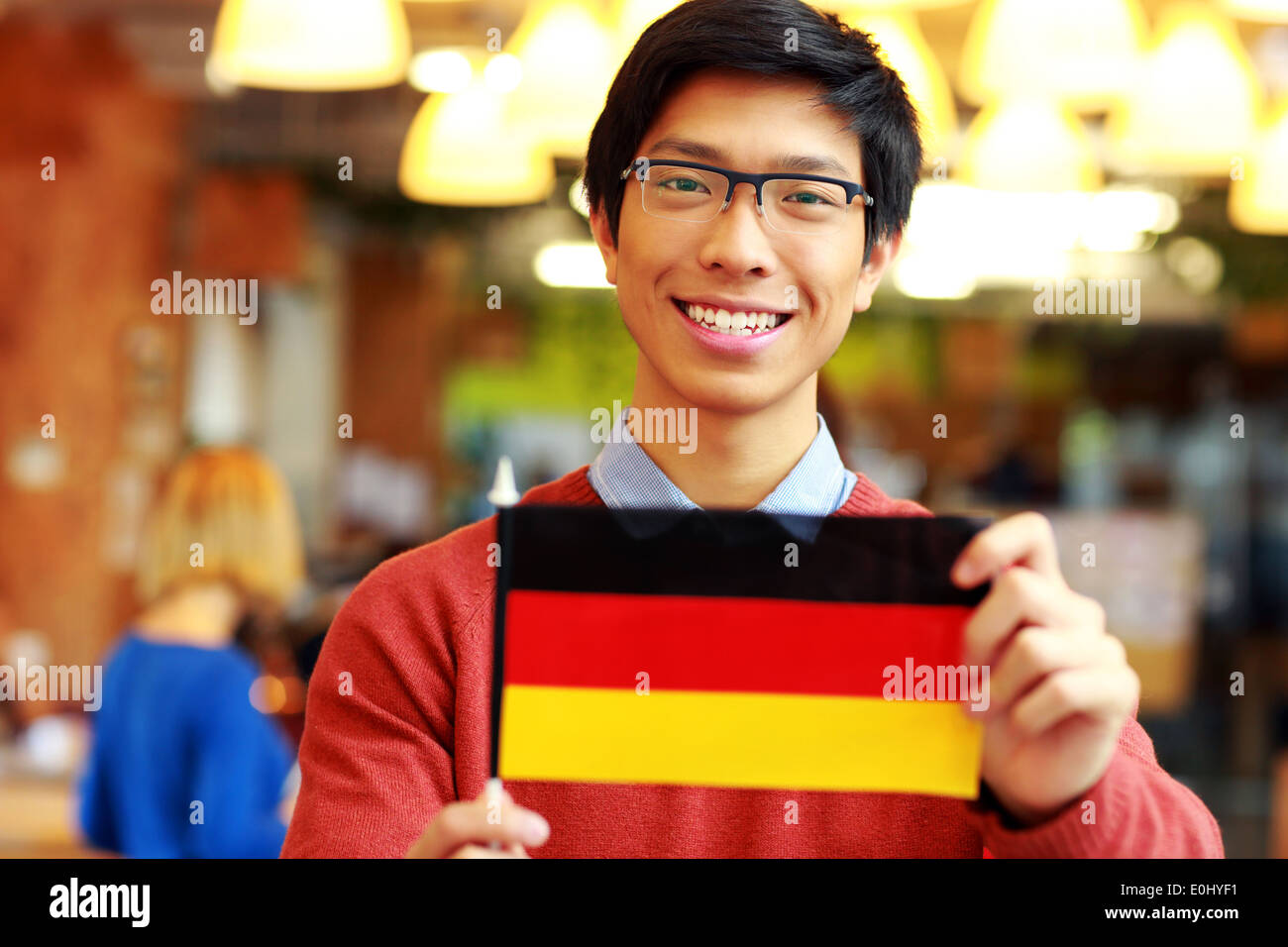 Happy asian student holding flag of germany Stock Photo - Alamy
