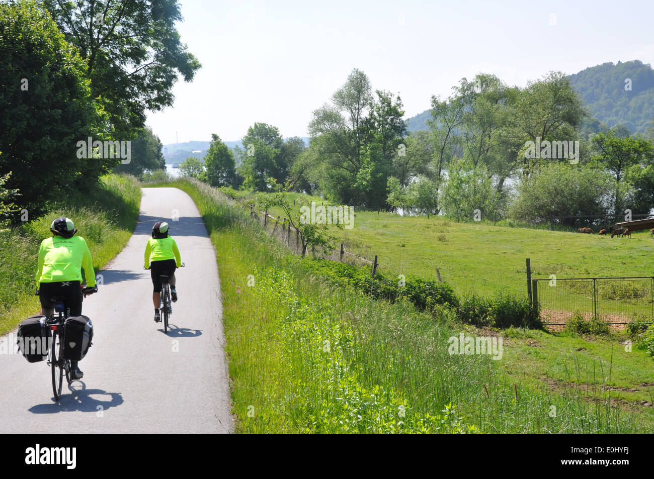 Two cyclists riding on a bike path alongside the Danube River east of ...