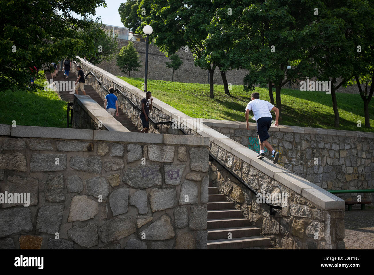 Young man running on a fence on stairs in castle gardens in Bratislava ...