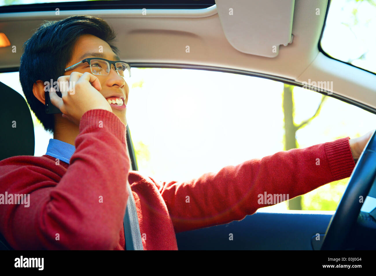 Young asian man driving car and speaking on mobile phone Stock Photo ...