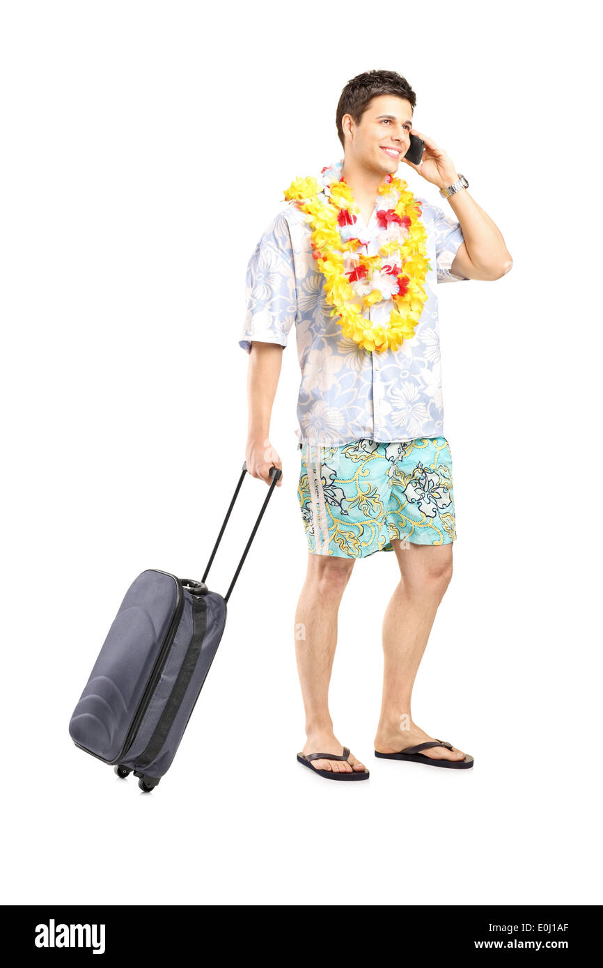 Male tourist talking on the phone and carrying his luggage Stock Photo ...