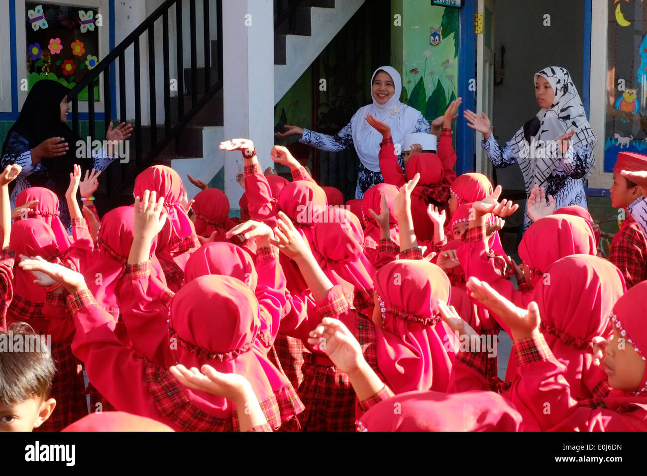 local primary school children in bright red uniforms line up in the ...
