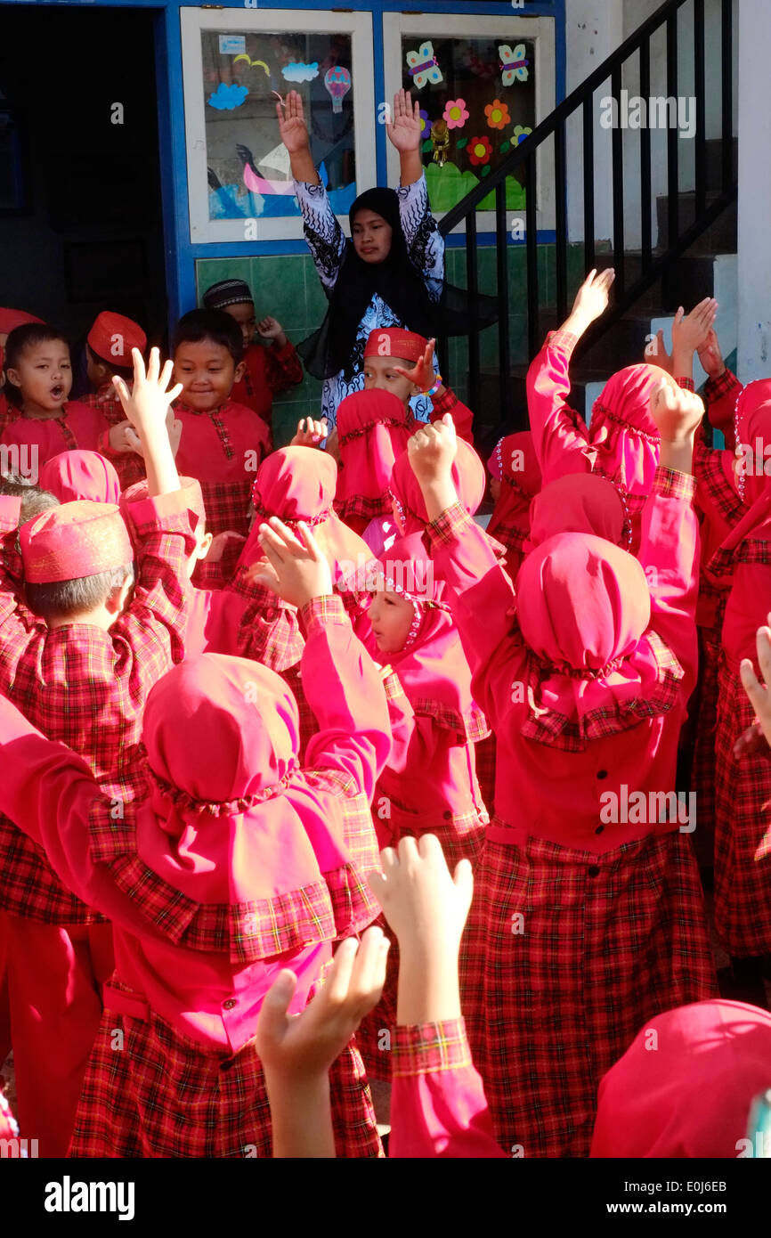 local primary school children in bright red uniforms line up in the ...