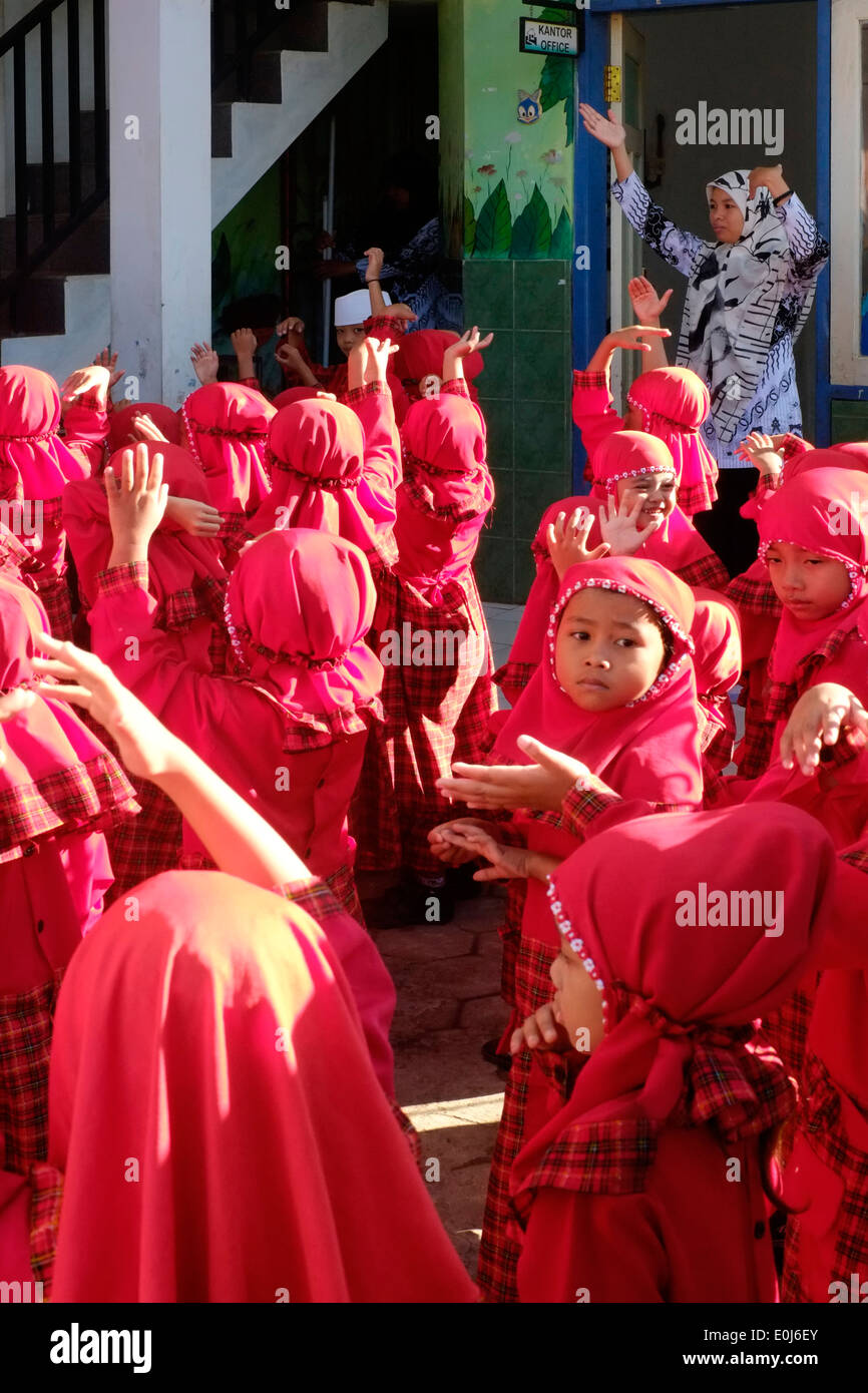 local primary school children in bright red uniforms line up in the ...