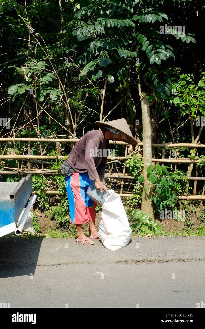 local man from a mobile rice sifting machine with bag of rice to sell ...