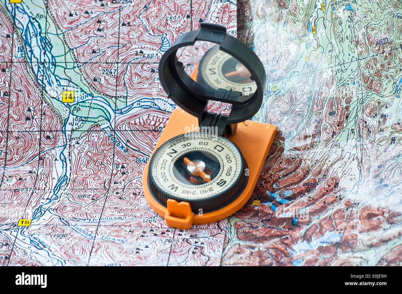 Magnetic compass in a red-black housing, equipped with a mirror, is on ...