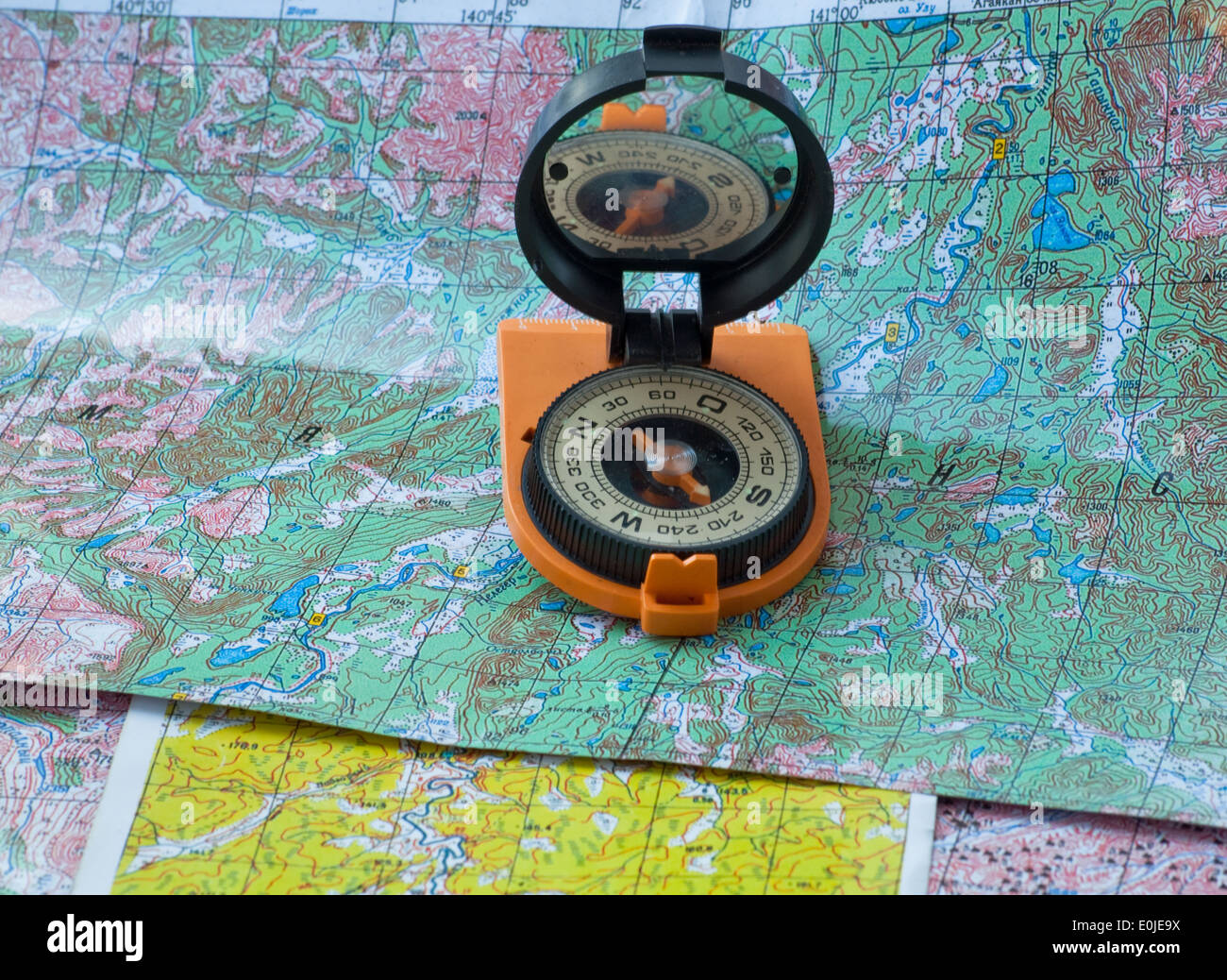 Magnetic compass in a red-black housing, equipped with a mirror, is on ...