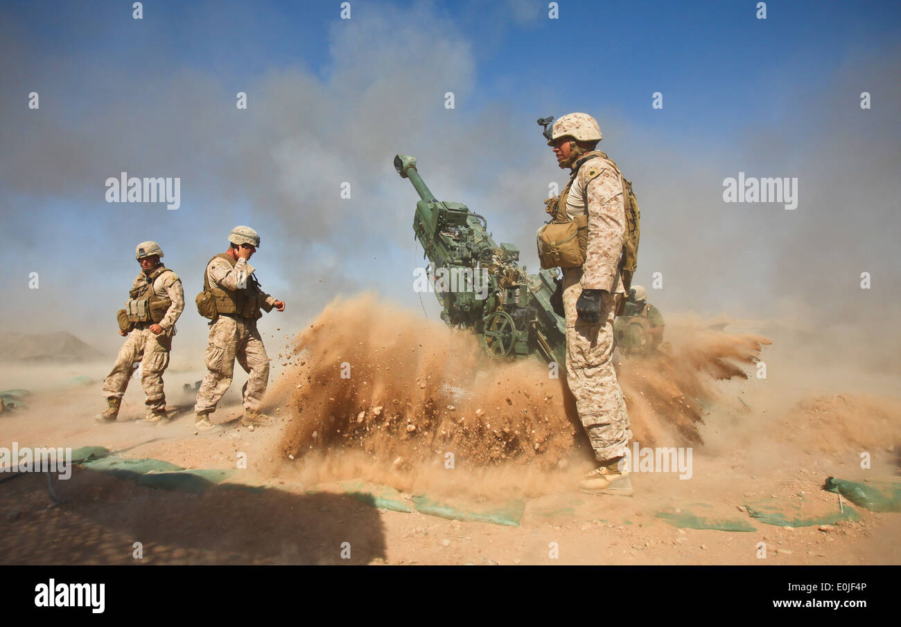 An M777 howitzer kicks rocks and dust into the air after firing during ...