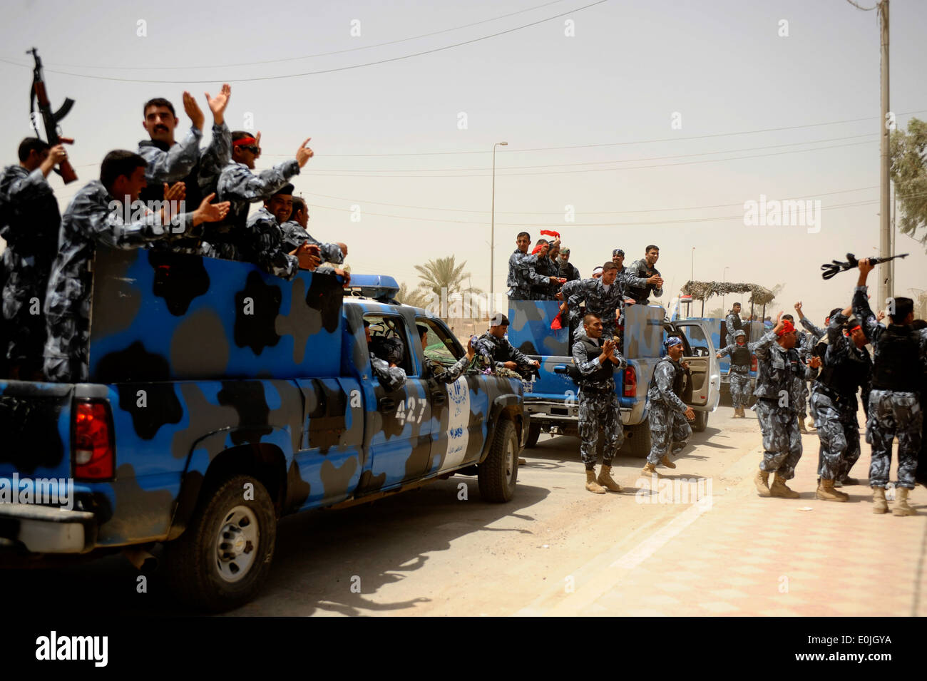 Iraqi police celebrate in the streets after a parade in recognition of ...