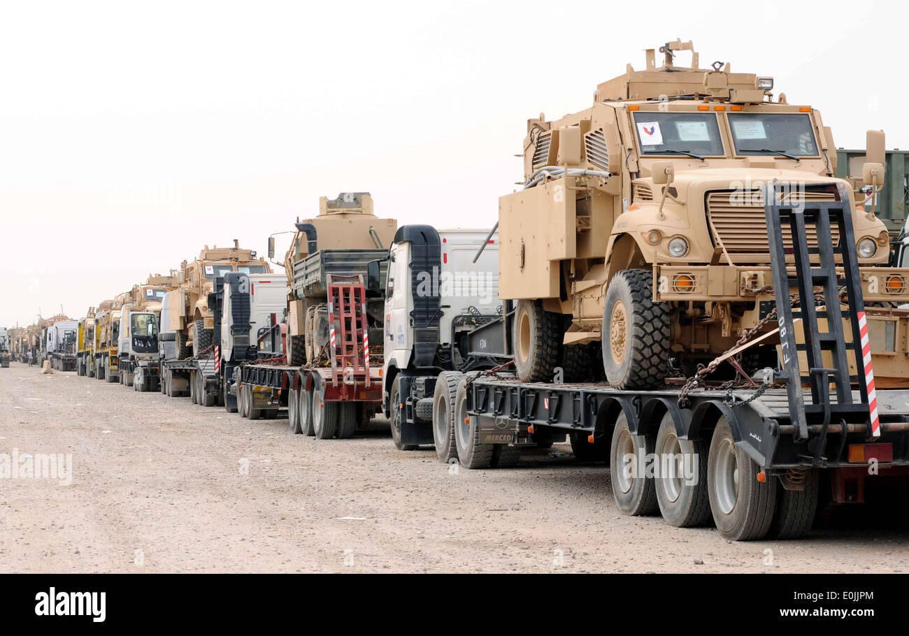 A convoy of Mine-Resistant Ambush Protected vehicles is lined up in a ...