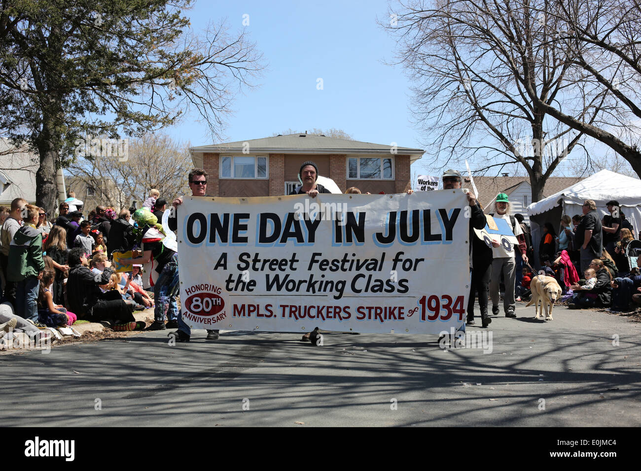Marchers in the May day parade in Minneapolis holding a banner about a ...