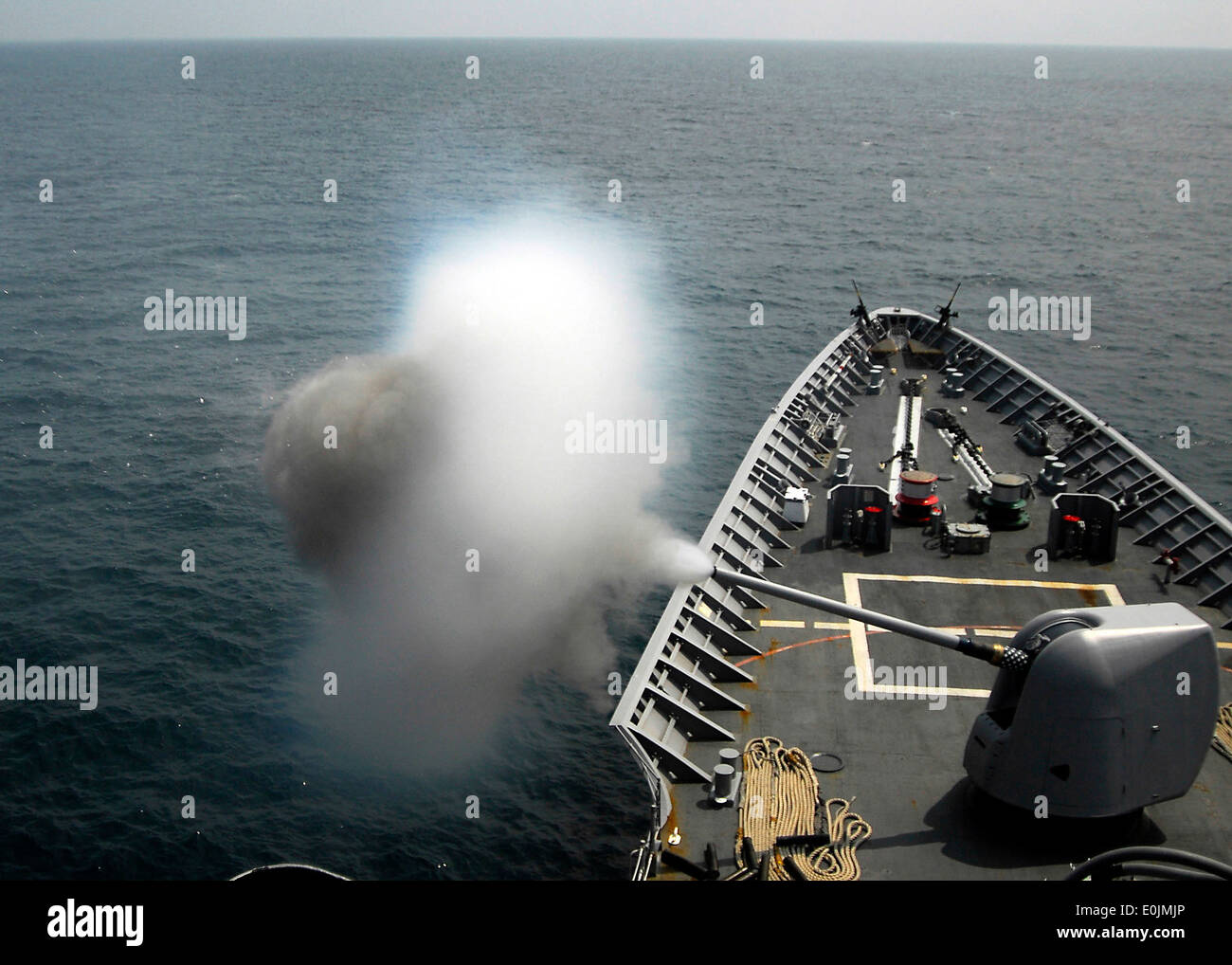 A 5-inch MK-45 Mod 2 light weight gun fires during a live fire exercise ...