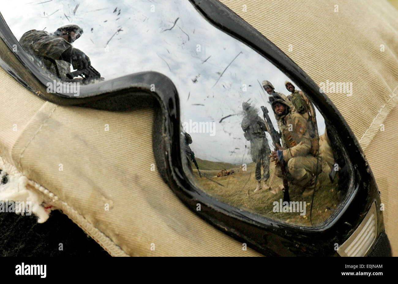 An Iraqi soldier's goggles catch the reflection of U.S. Army Staff Sgt ...