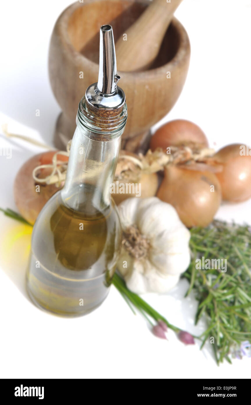oil bottle with onions, garlic, herbal and a pestle on white background ...