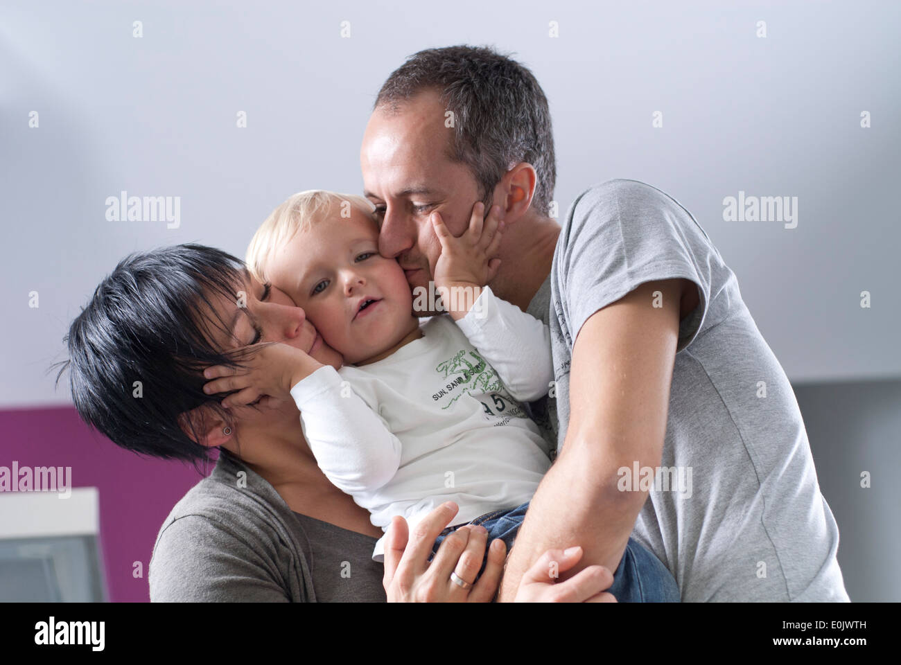 parents kissing their son at home Stock Photo - Alamy