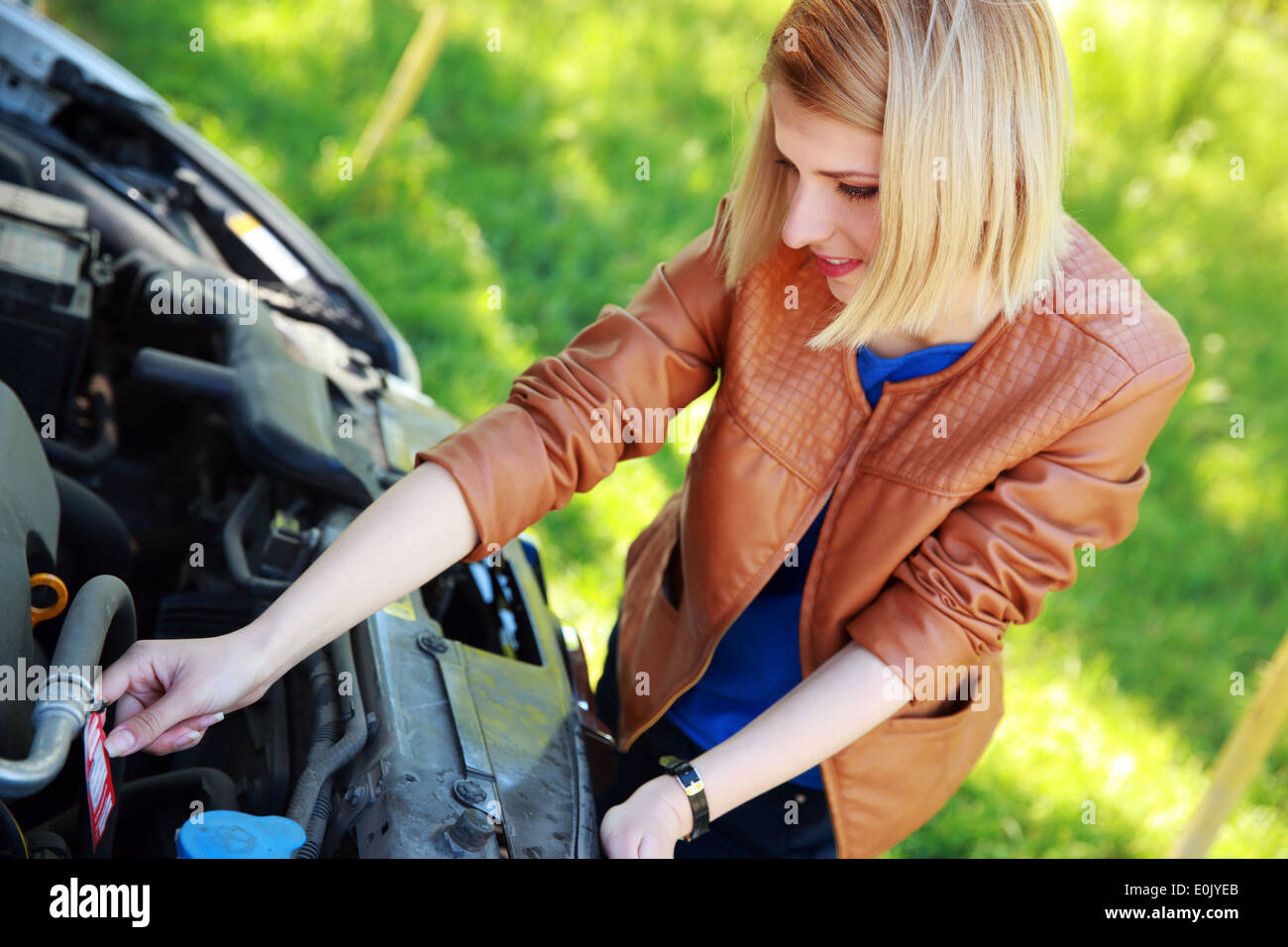 Beautiful woman checking her car engine Stock Photo - Alamy